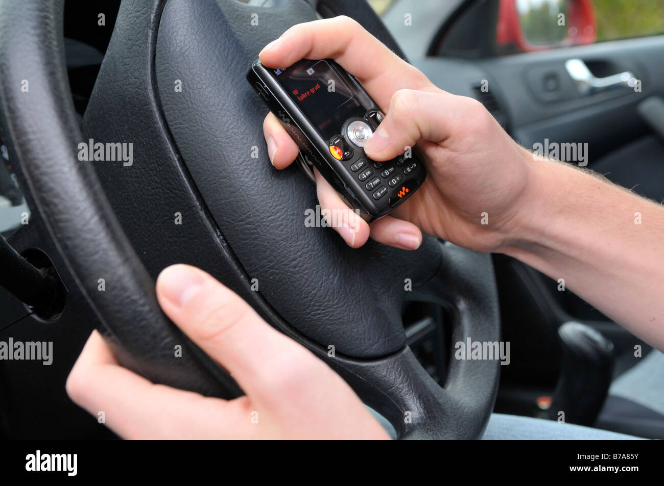 Hand of a driver, writing a text message while in the car Stock Photo ...