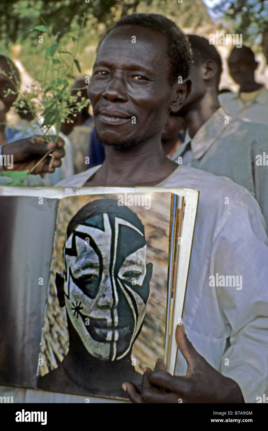 A man holding up a book by photographer Leni Riefenstahl showing an ...