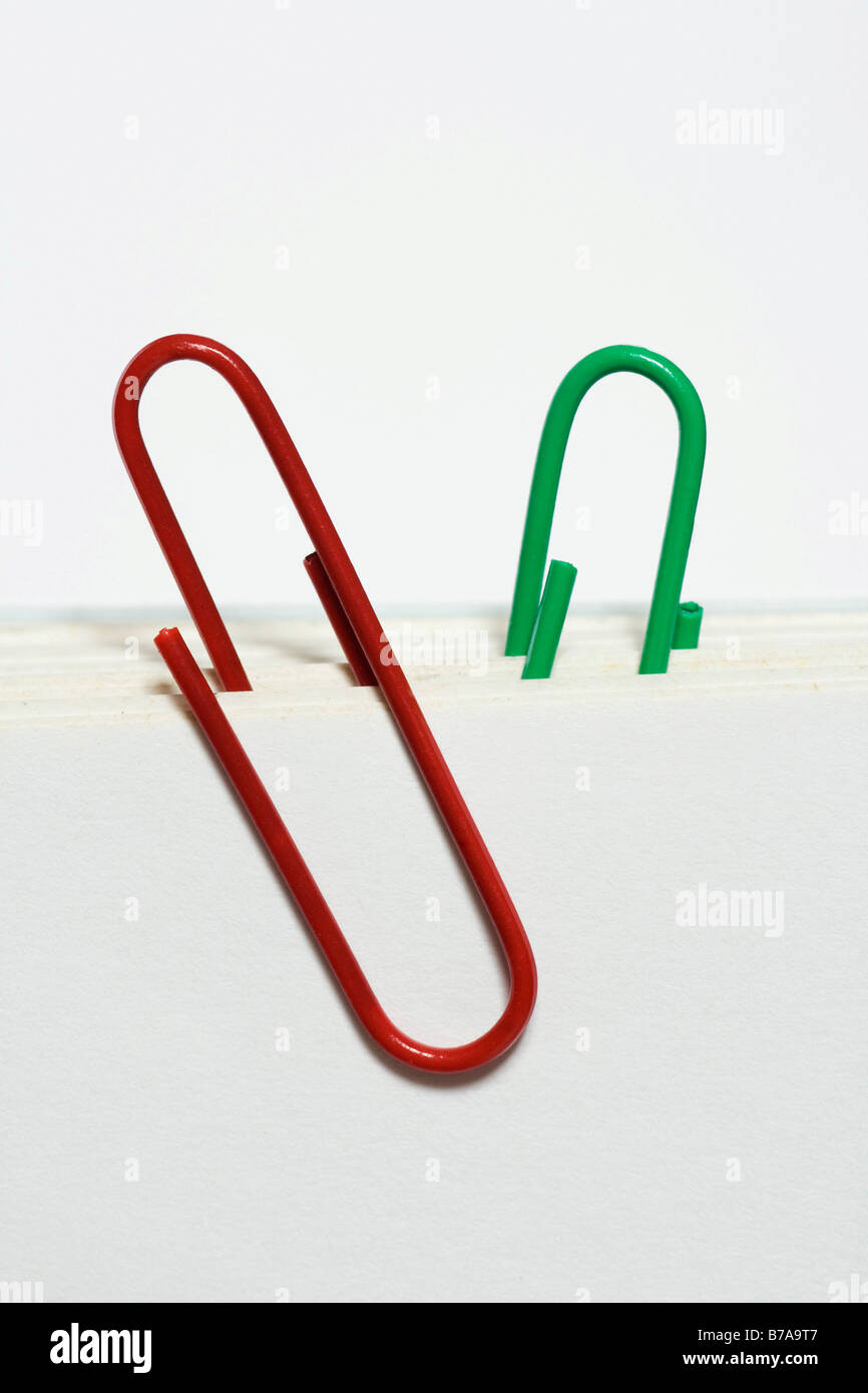 Two colored paper clips and paper Stock Photo - Alamy