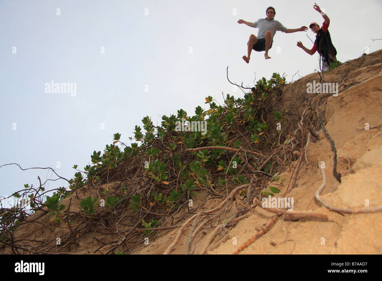 A youth jumping down a steep sand dune on the Kosibay coastline Stock ...