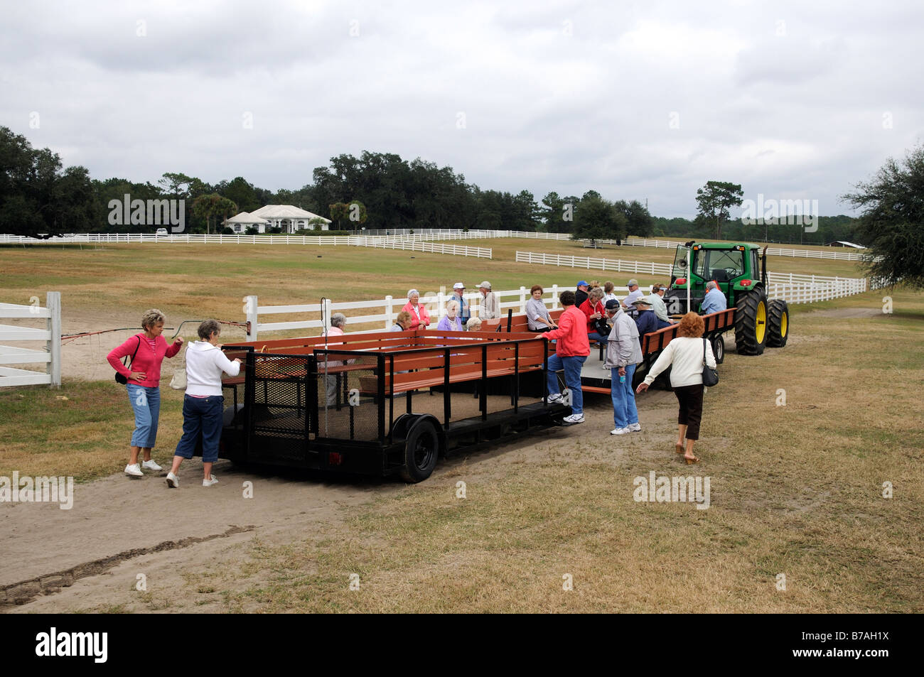 Tourists boarding a tractor trailer ride farm tour around the New ...