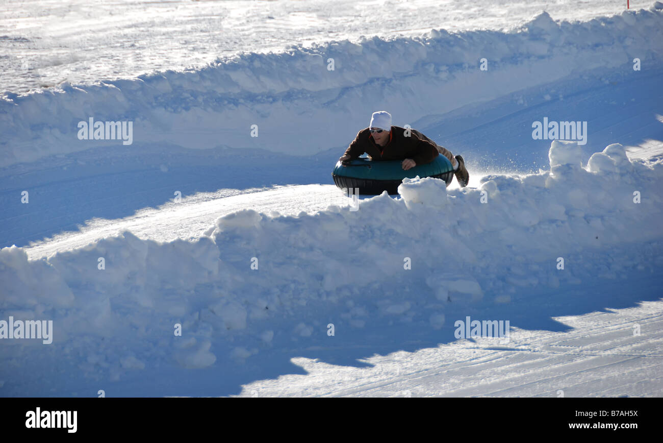 man tubing fast down the hill with snow background Stock Photo - Alamy