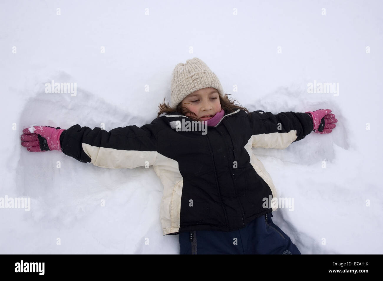 Girl making snow angel Stock Photo - Alamy