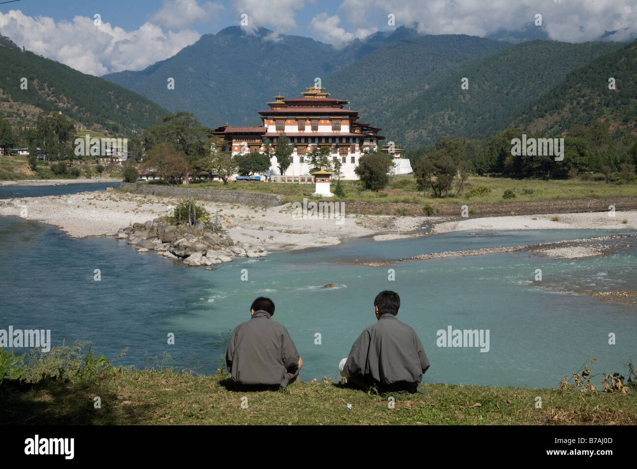 Two Bhutanese men dressed in traditional ghos look out towards Punaka ...
