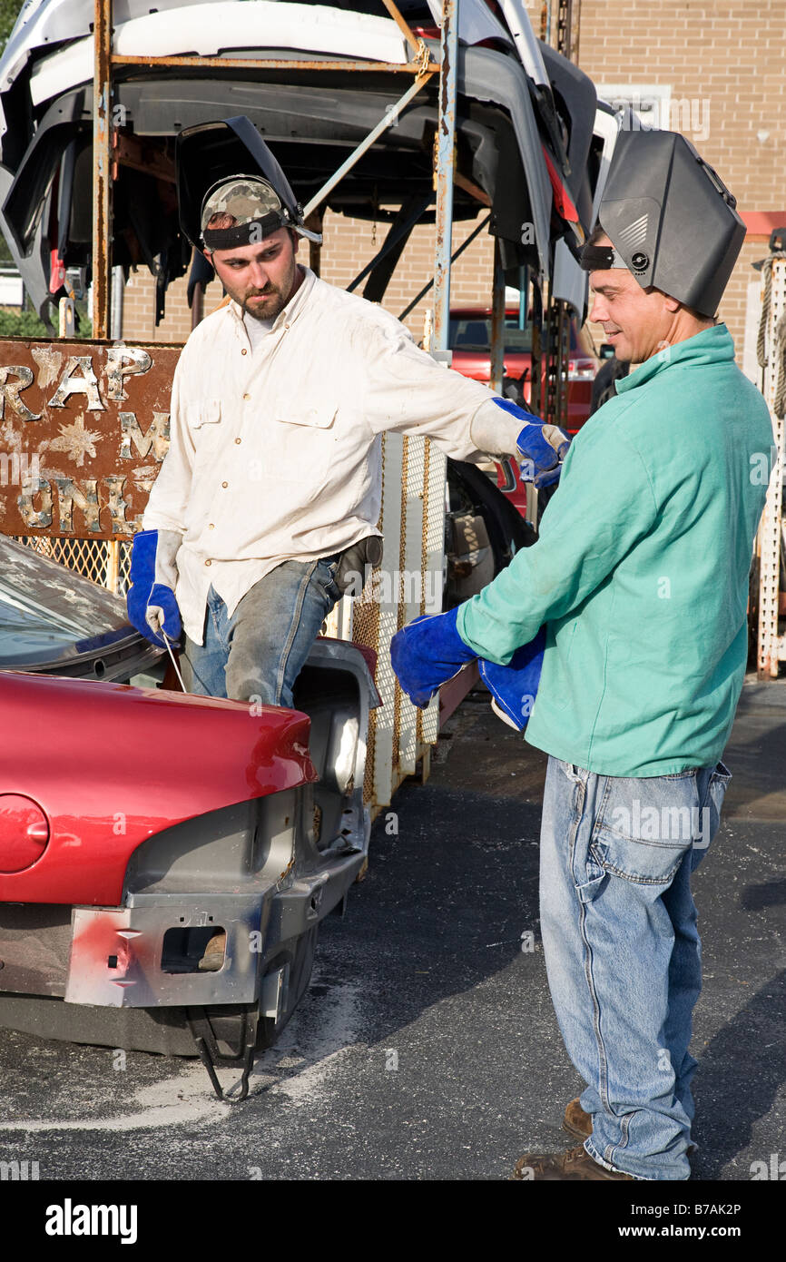 Two metal workers in the scrap metal yard Stock Photo - Alamy