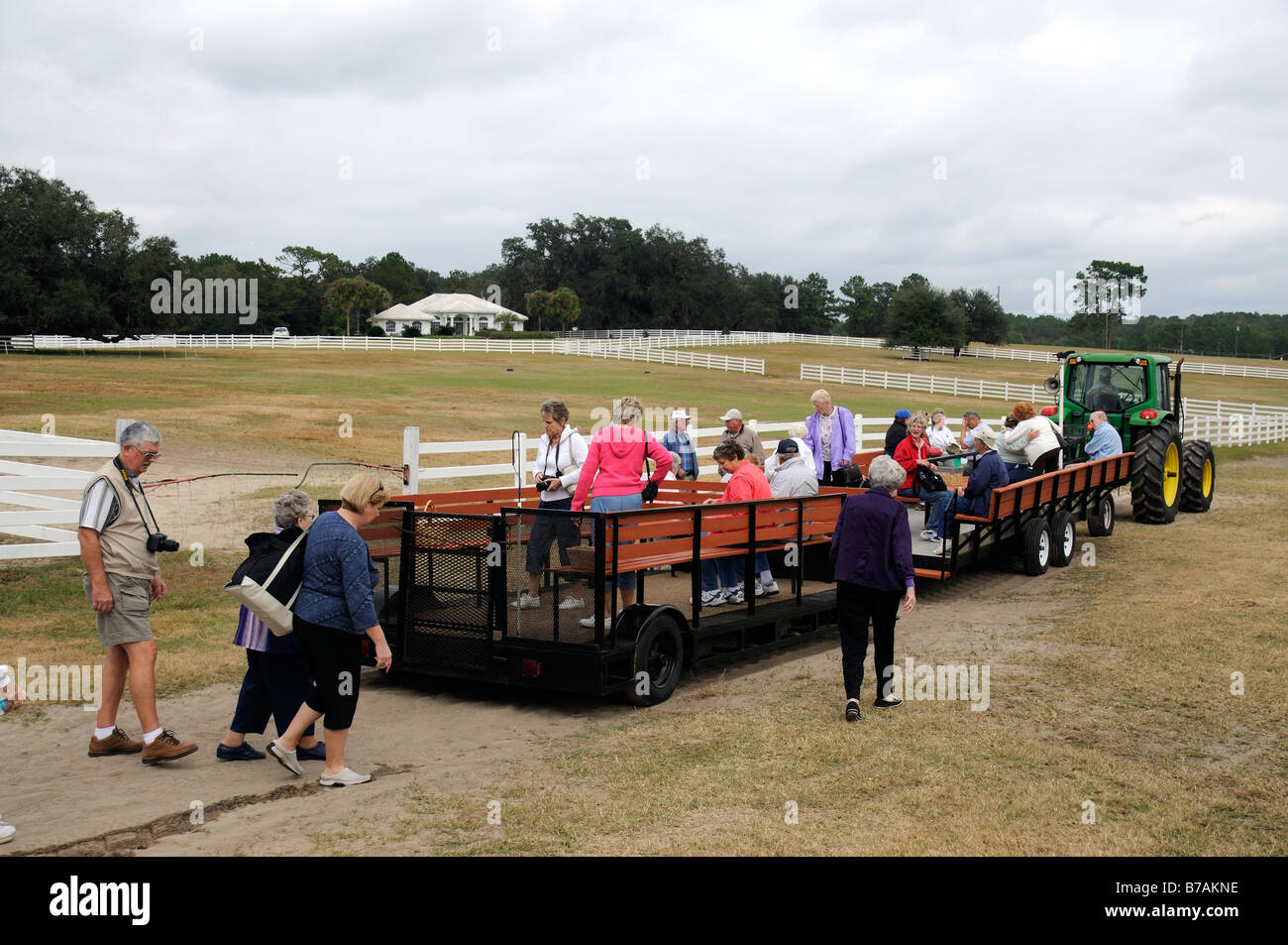 Tourists boarding a tractor trailer ride farm tour around the New ...