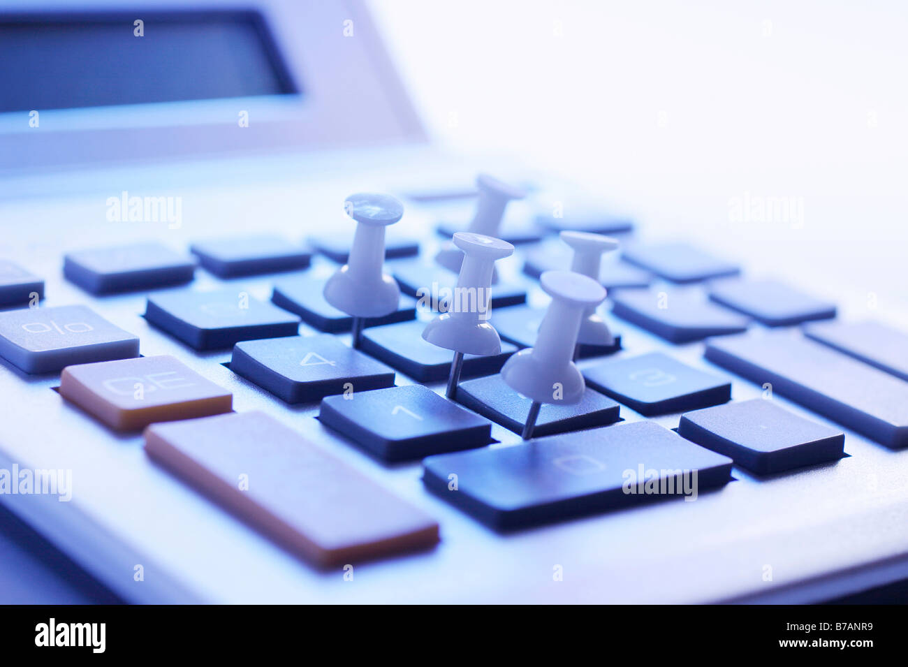 Pinboard tacks on a calculator Stock Photo - Alamy