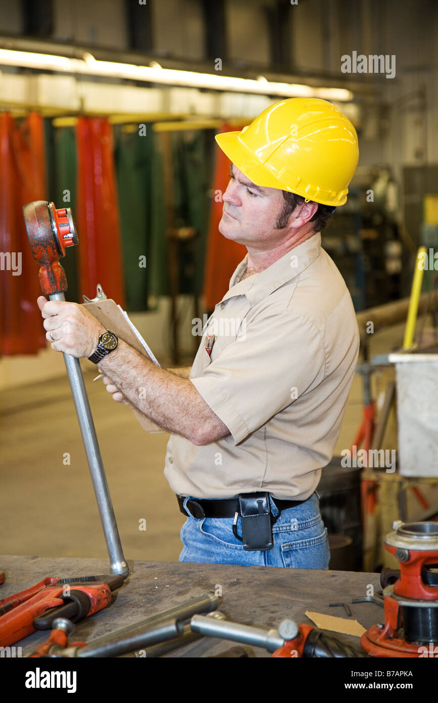 Safety inspector checking the funtionality of tools in a metal working ...