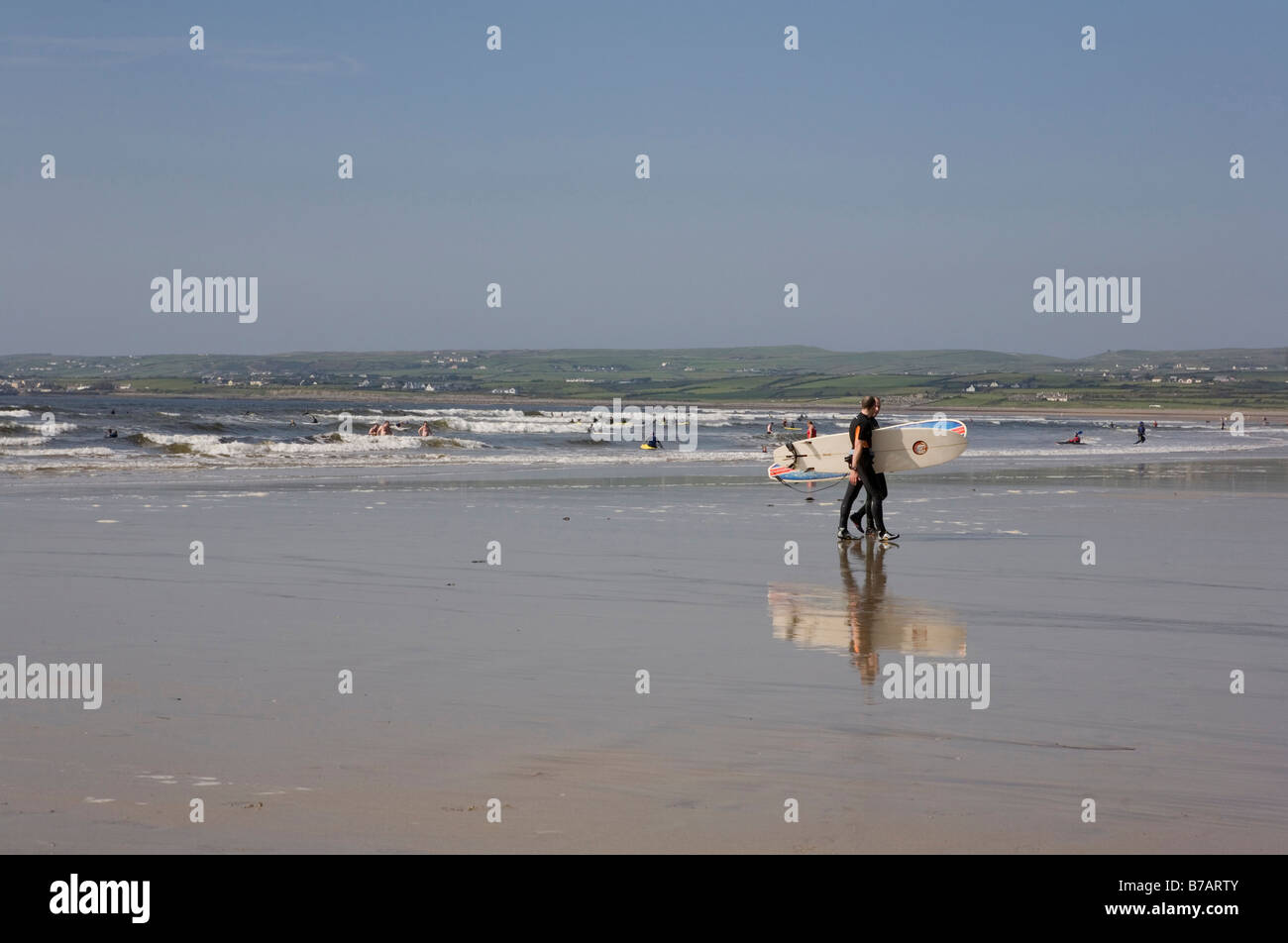Surfers on the beautiful beach of Lahinch, County Clare, Ireland, on a ...