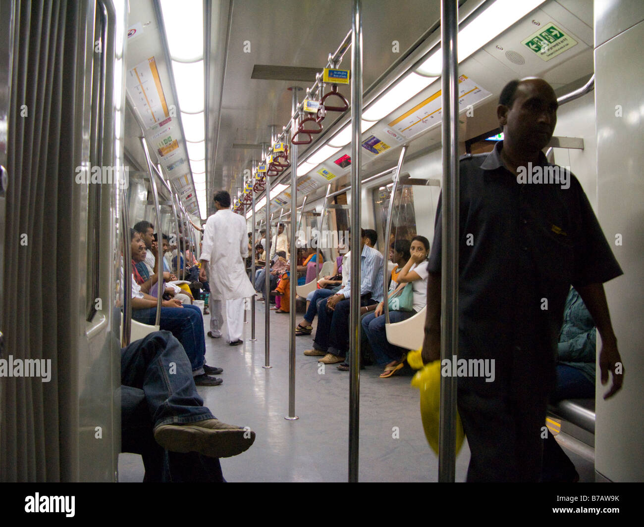 A yellow line tube train carriage interior with passengers. Delhi Metro ...
