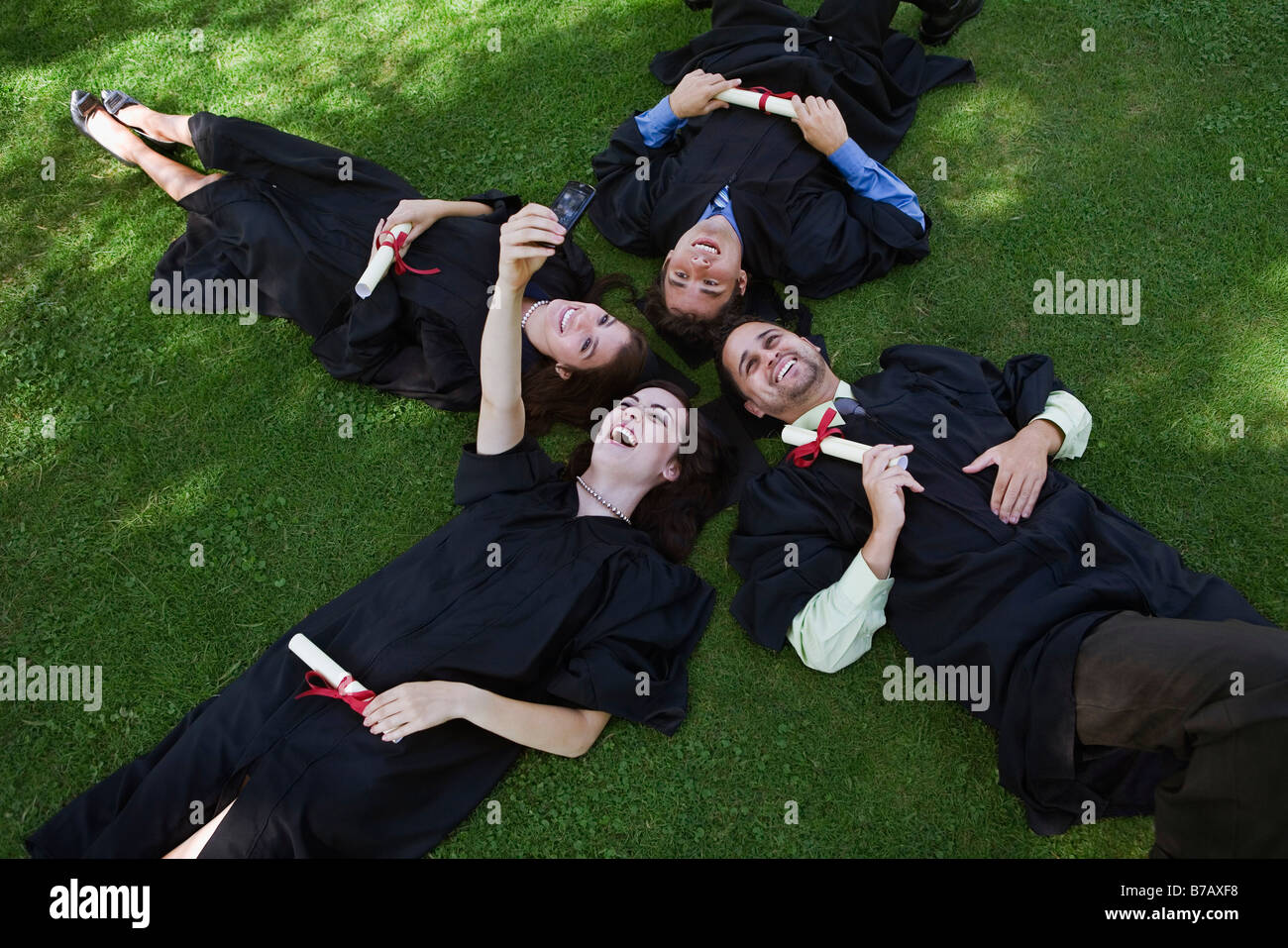 College Graduates Lying on Ground Taking Pictures With Camera Phone ...