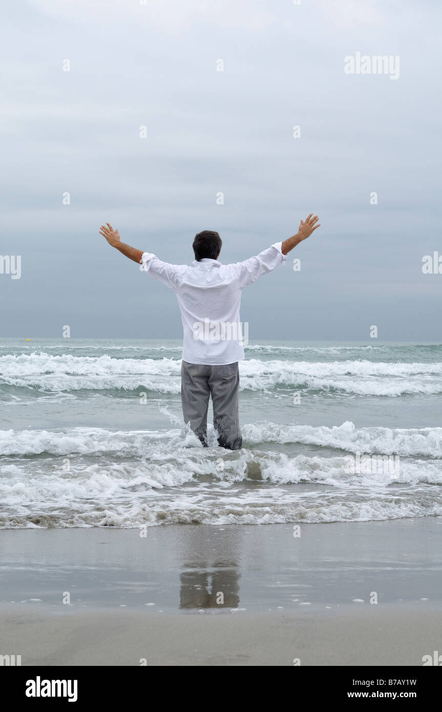 Man Standing in Waves on Beach Stock Photo - Alamy