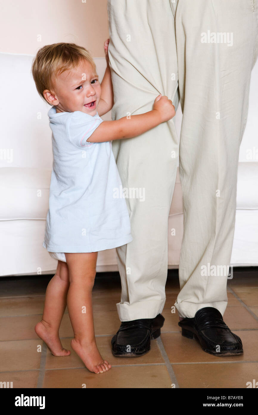 Baby Boy Crying, Grabbing Dad's Leg Stock Photo - Alamy