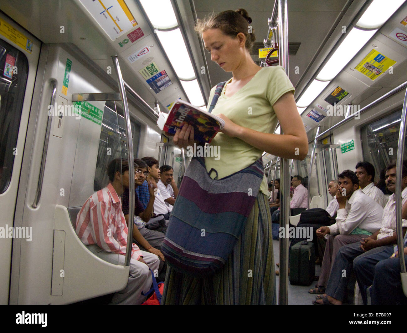 A western woman tourist on a yellow line tube train carriage interior ...