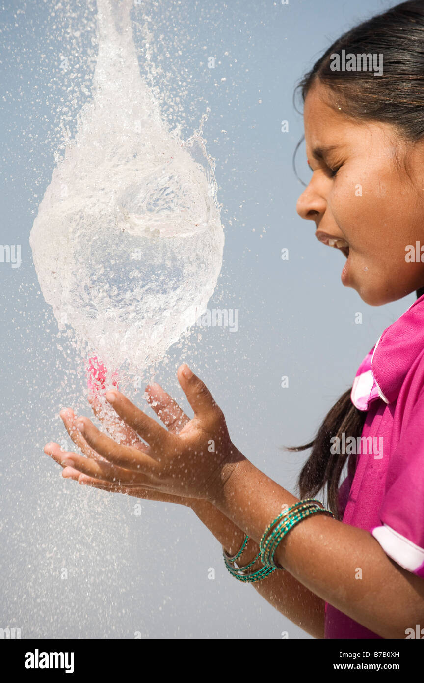 Indian girl catching a burst water balloon. Andhra Pradesh. India Stock ...