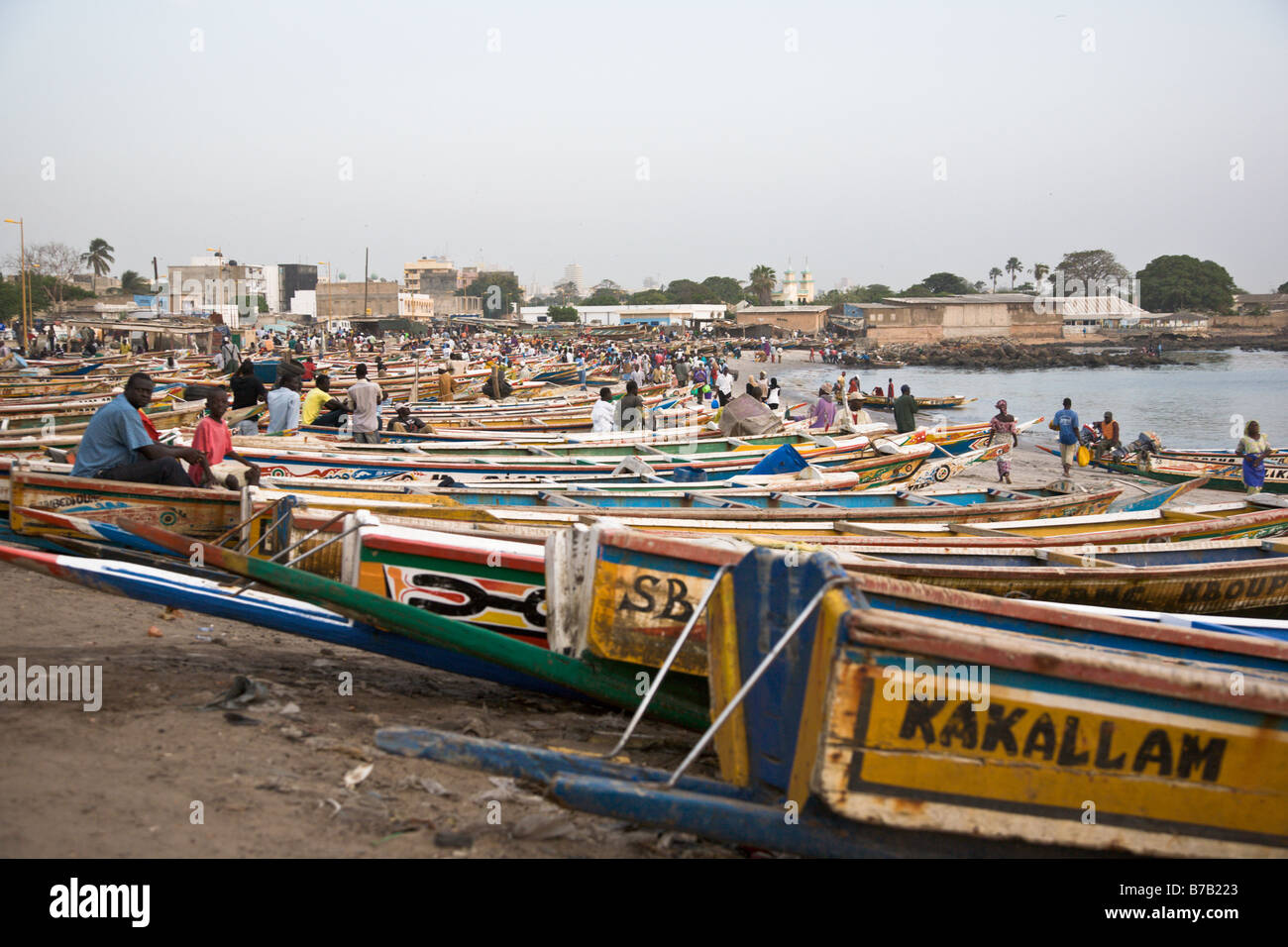 Colorfully painted fishing boats line the beach at this fish market in ...