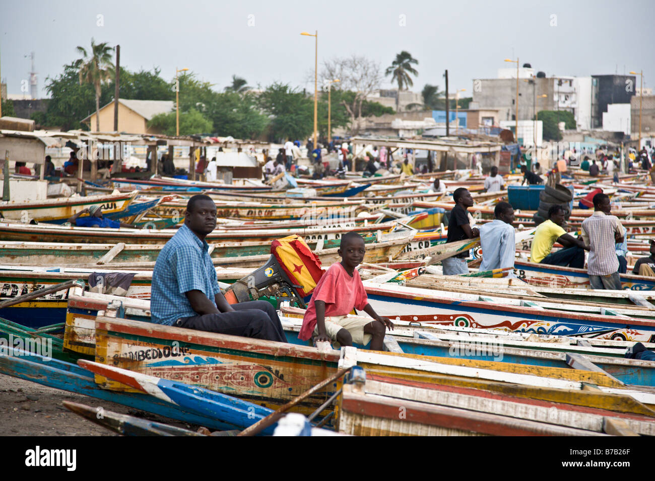 Colorfully painted fishing boats line the beach at this fish market in ...