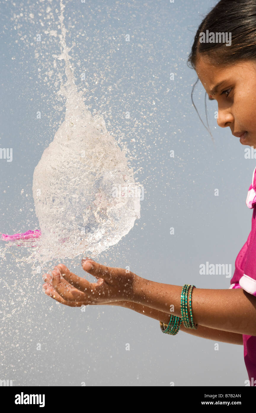 Indian girl catching a burst water balloon. Andhra Pradesh. India Stock ...