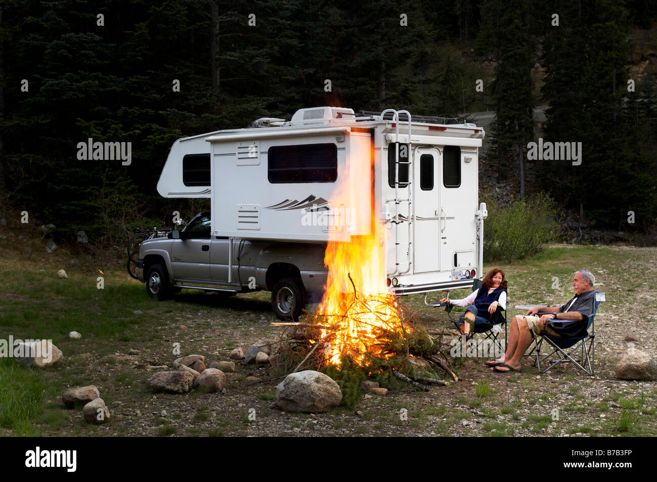 A couple enjoys a fire by their camper Near Duffy lake on the Sea to ...