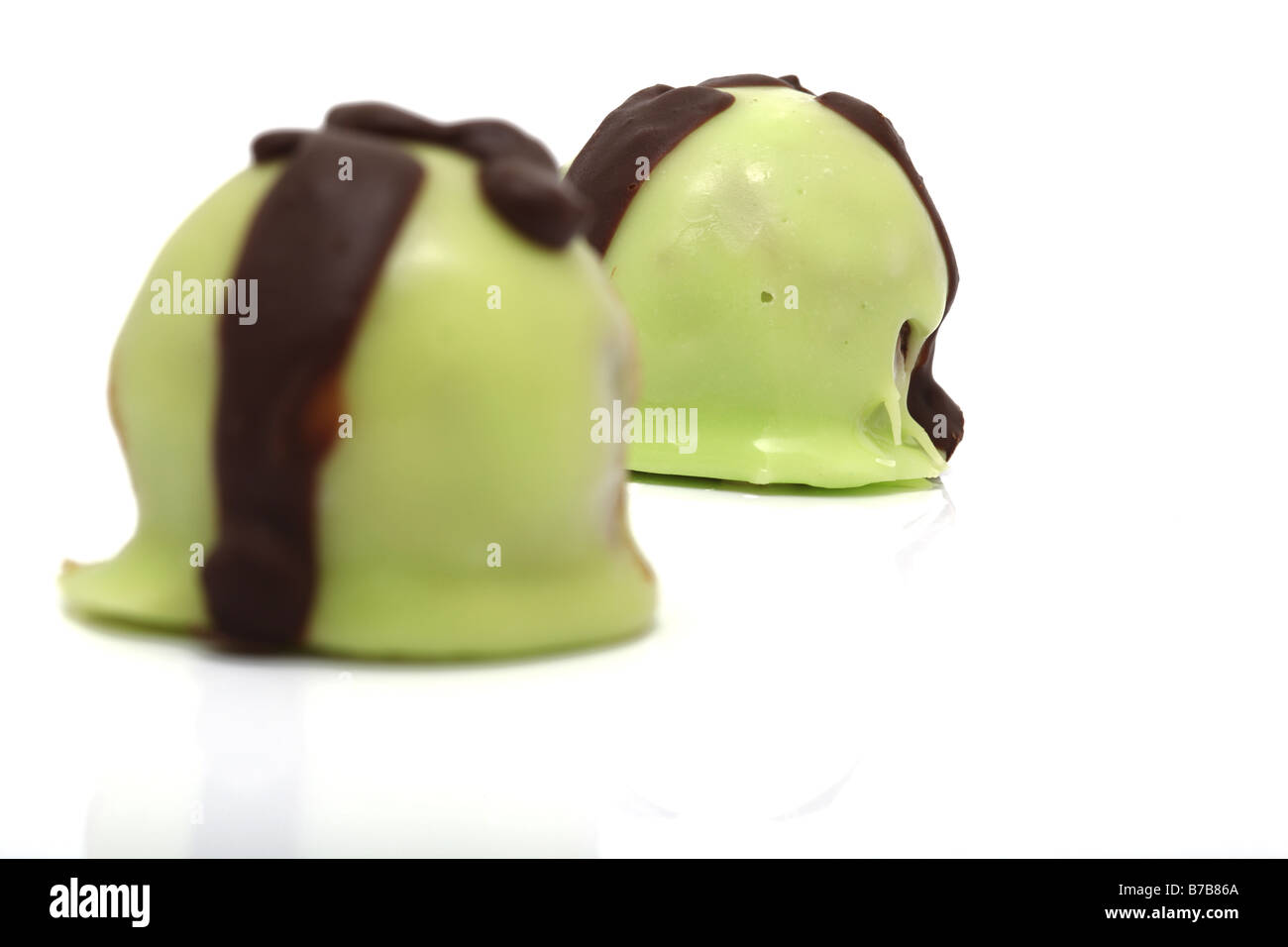 closeup two green sweets with reflection isolated on white background ...