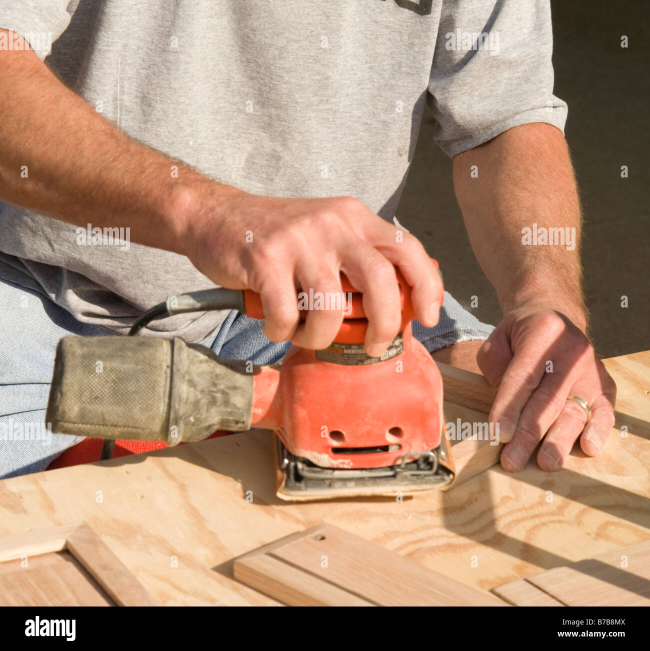 a man's hand using an electric sander on a woodworking project Stock ...