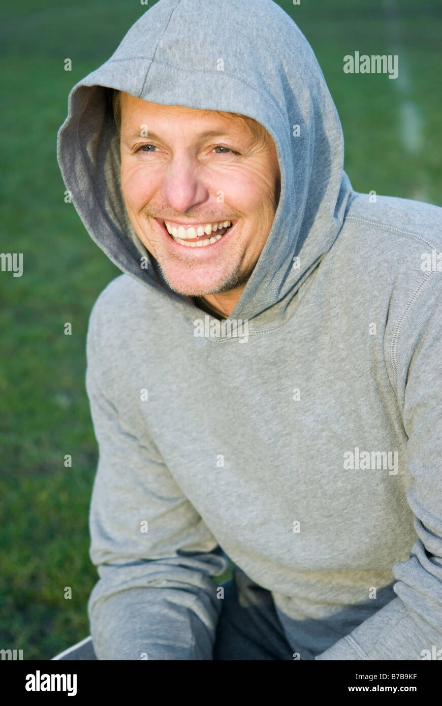 A Portrait Of A Happy Smiling Forties Man Wearing A Grey Hooded