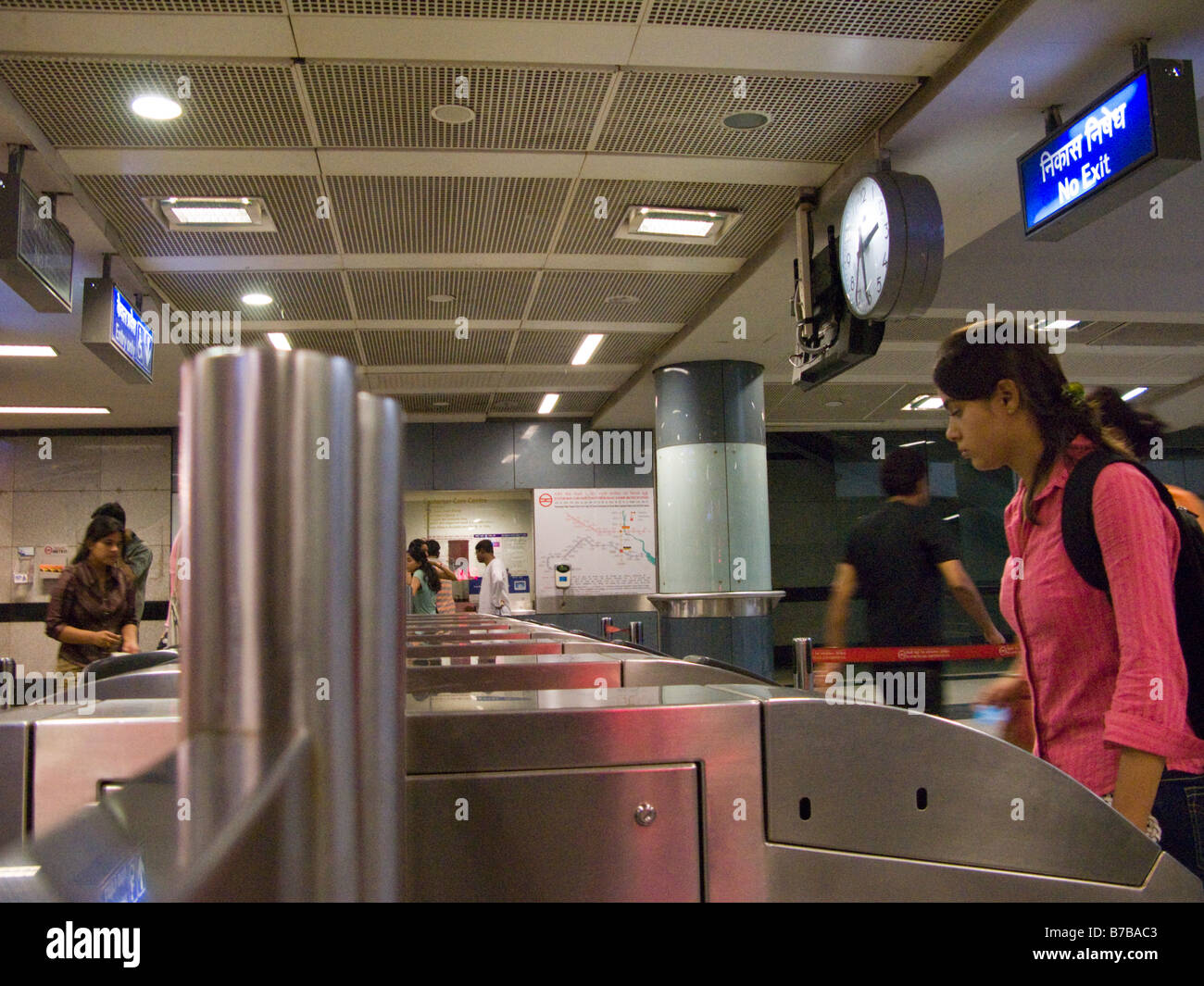 A passenger passing through the entrance barrier at a station on the ...