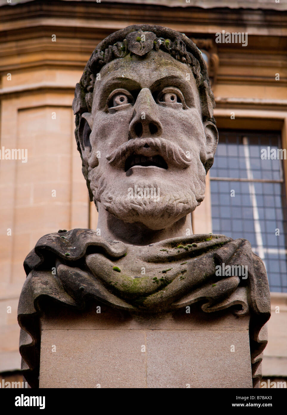 A scary faced stone head gargoyle on the wall surrounding the ...