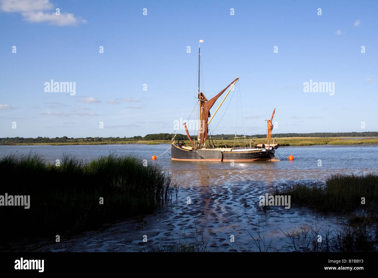 A Victorian spritsail barge lies at anchor on the River Alde near ...