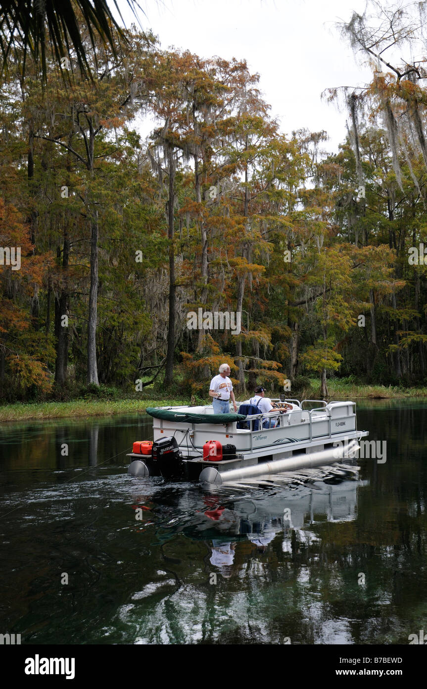 Two men boating and fishing from a pontoon boat on the Rainbow River ...