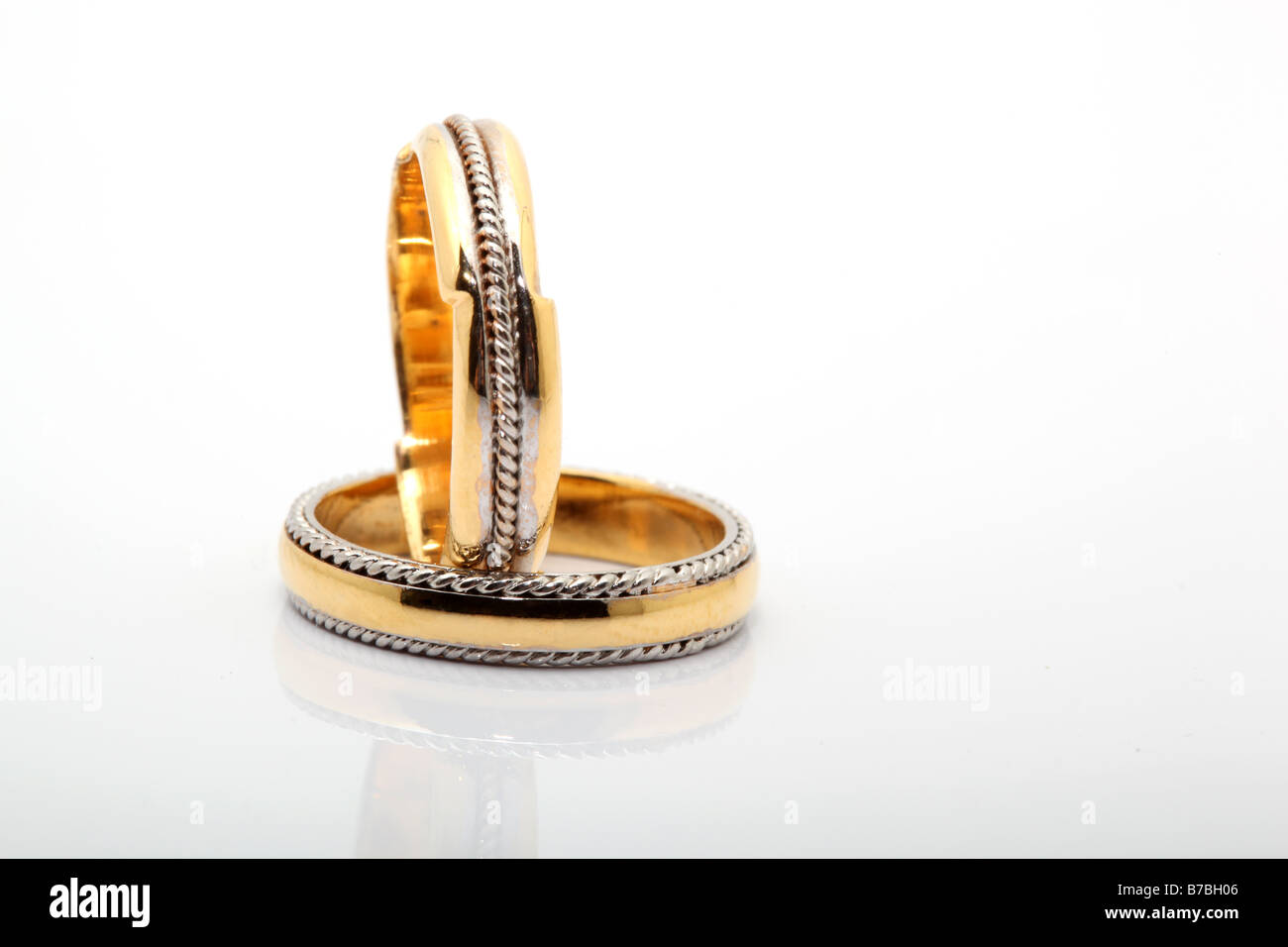two wedding rings on white background with reflection Stock Photo - Alamy