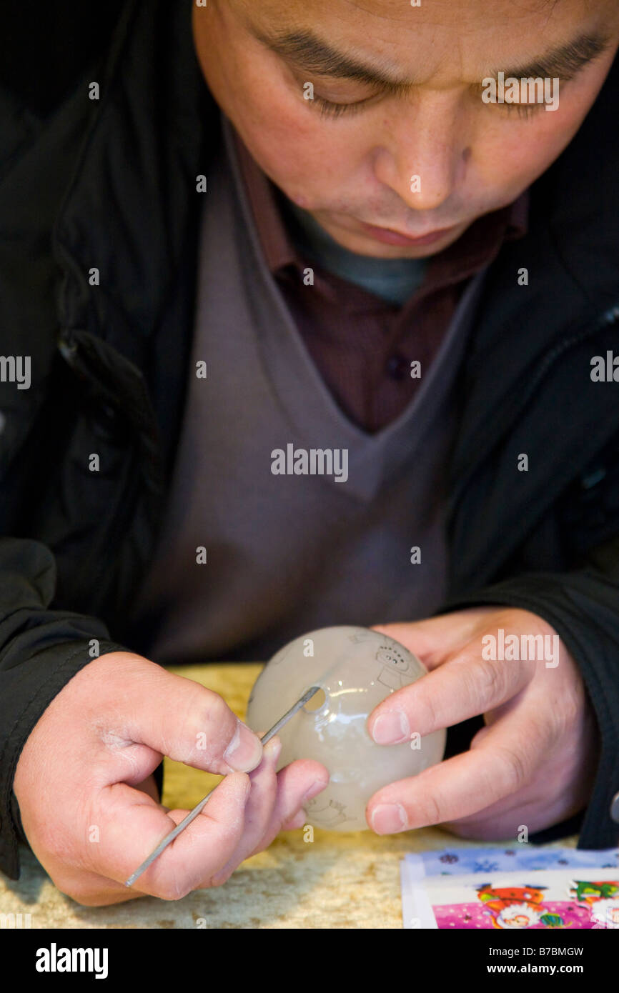 An artist hand paints the inside of a Christmas bauble in Cologne ...