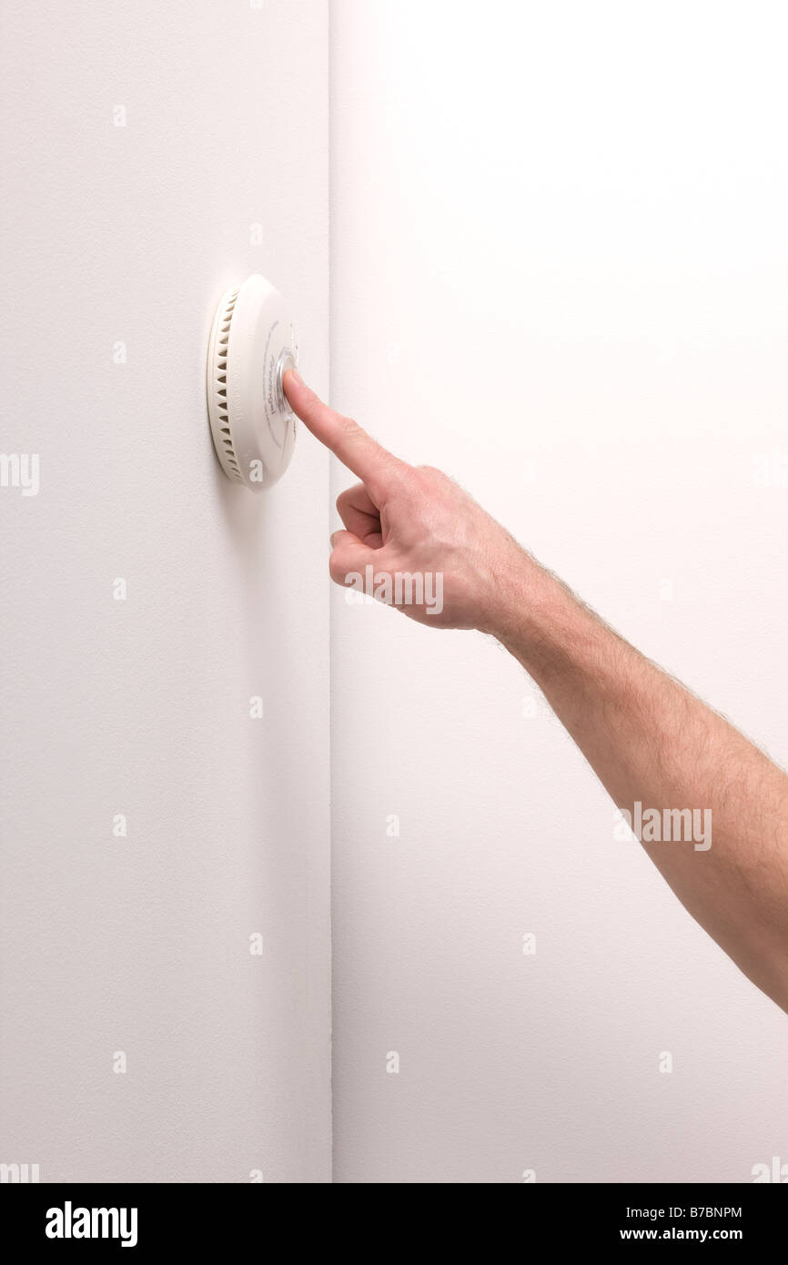 Man testing a domestic fire alarm is working correctly Stock Photo - Alamy