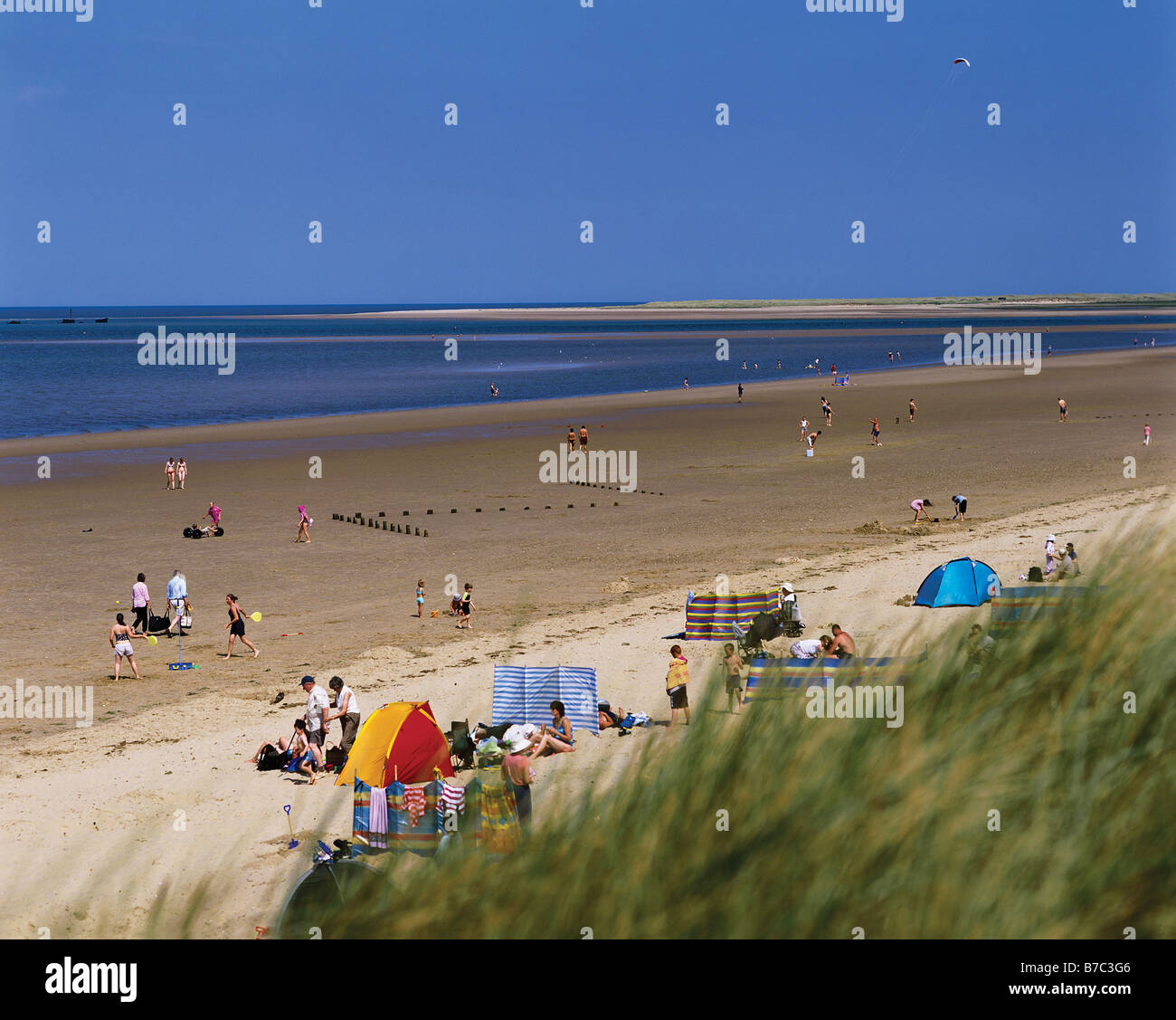 Golden sand beach backed by dunes overlooking the shallow Brancaster ...