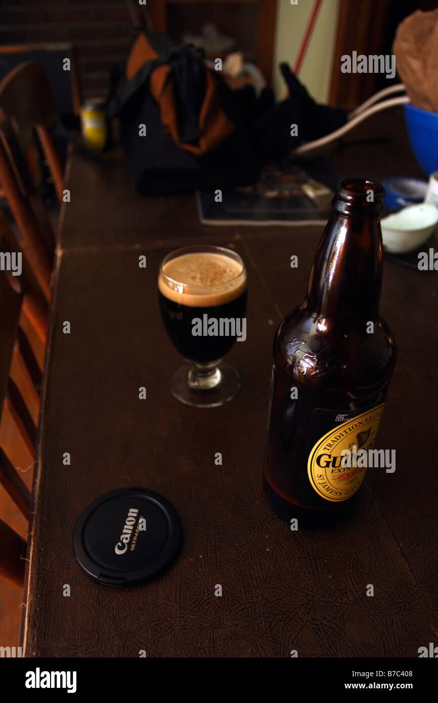 Guinness Extra Stout beer 1 pint 6 oz bottle with glass on tabletop ...