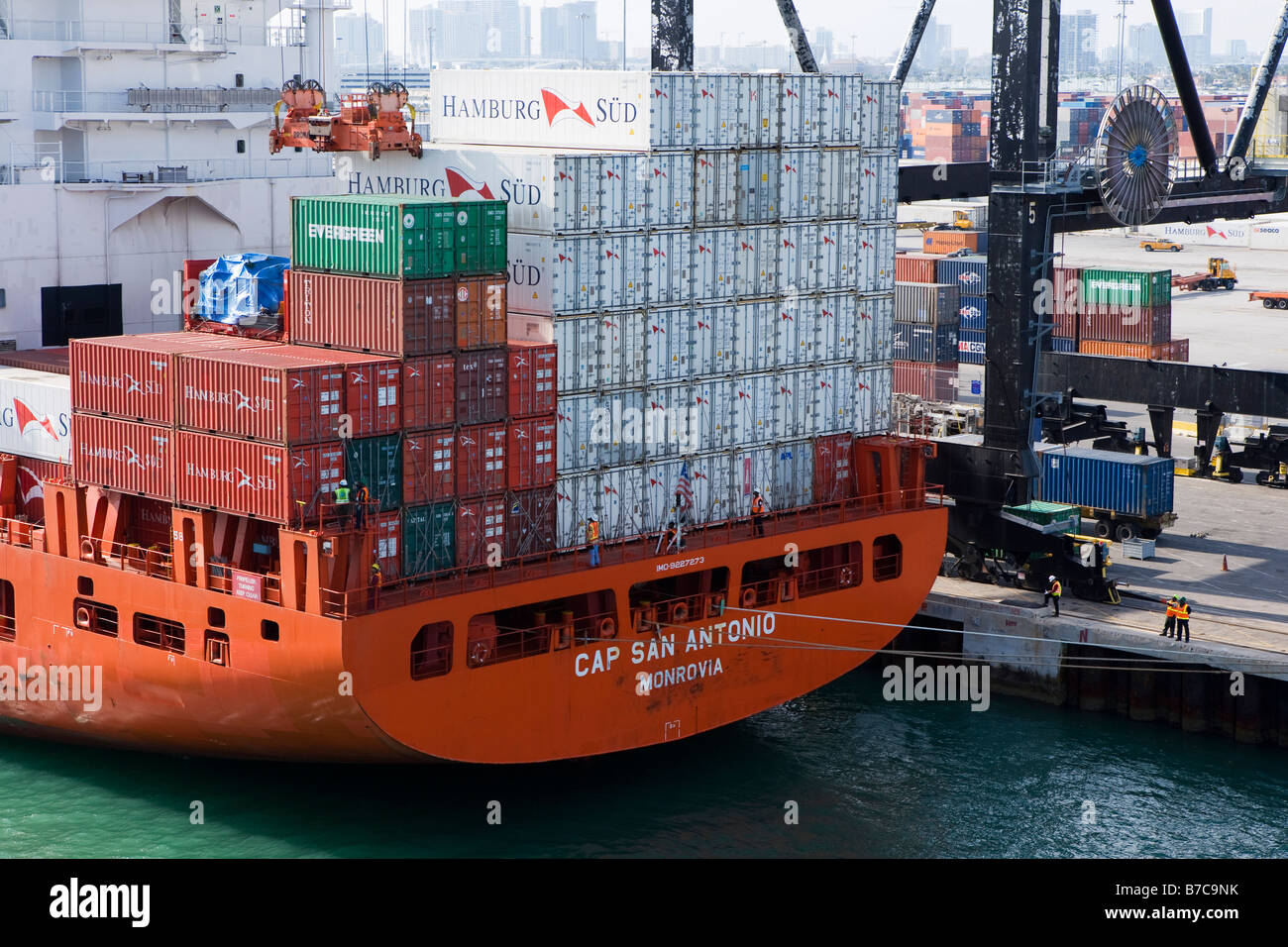 Dockers and gantry cranes unload a container ship as it docks in the ...