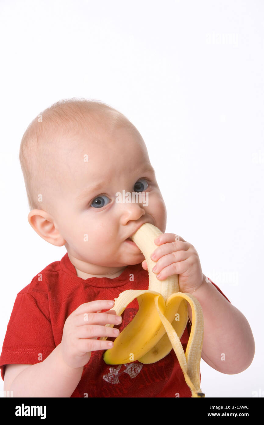 Toddler eats a banana Stock Photo - Alamy
