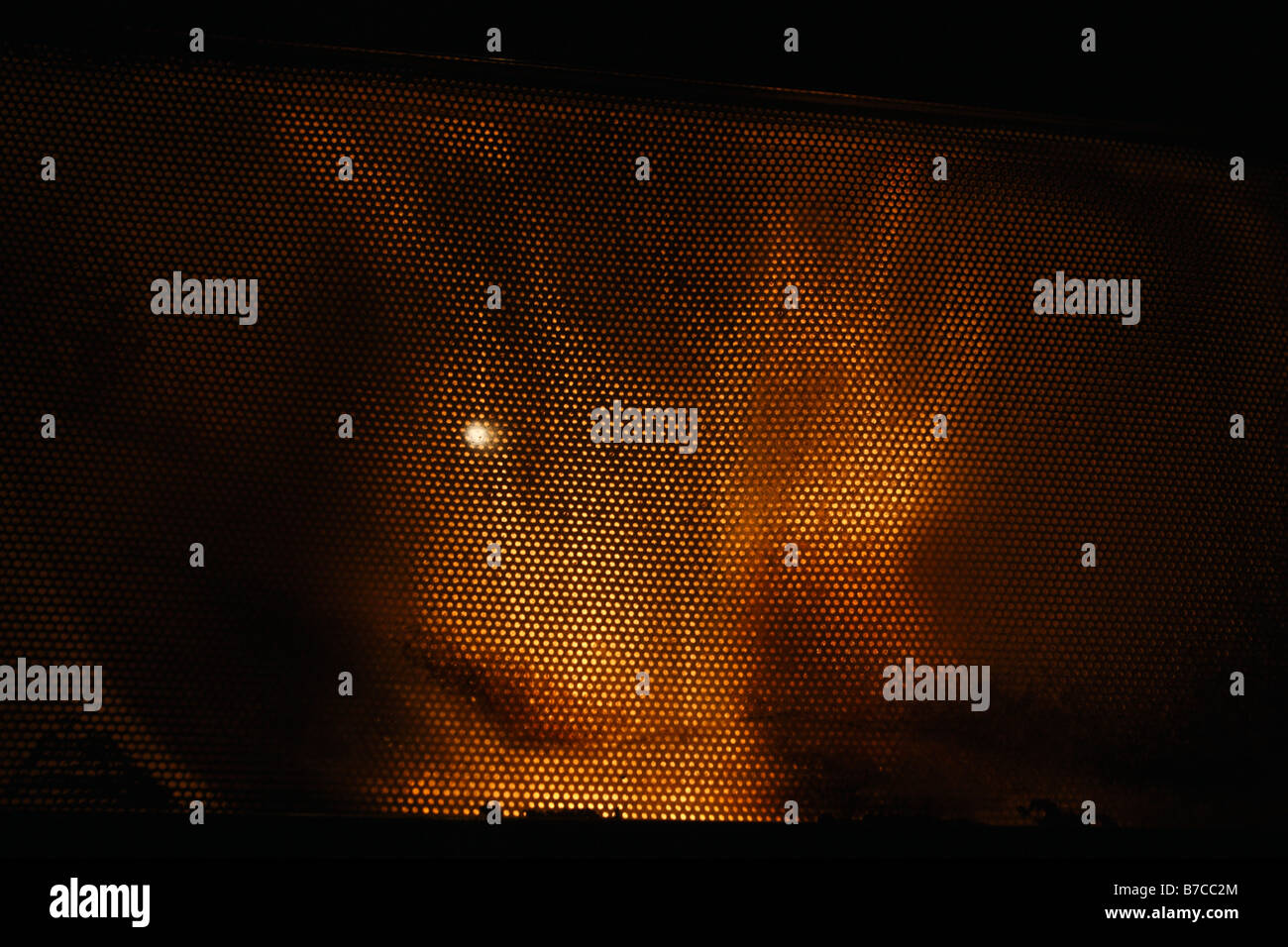 Flames behind fireplace grille Stock Photo - Alamy