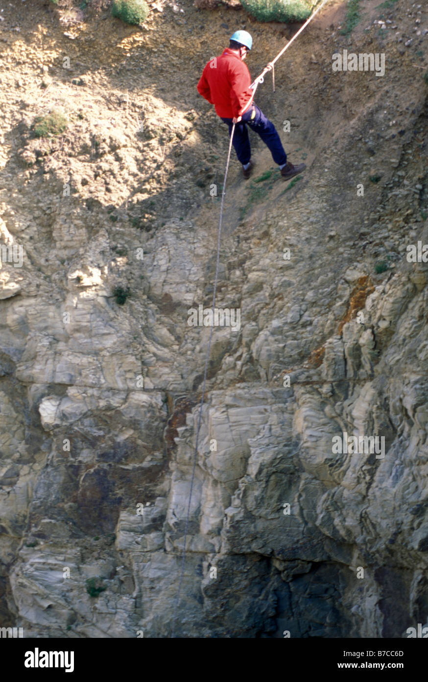 Man Abseiling down a cliff Stock Photo - Alamy