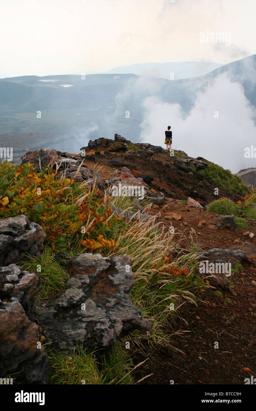 Walker standing by a rising steam cloud from active volcano Aso (Mount ...