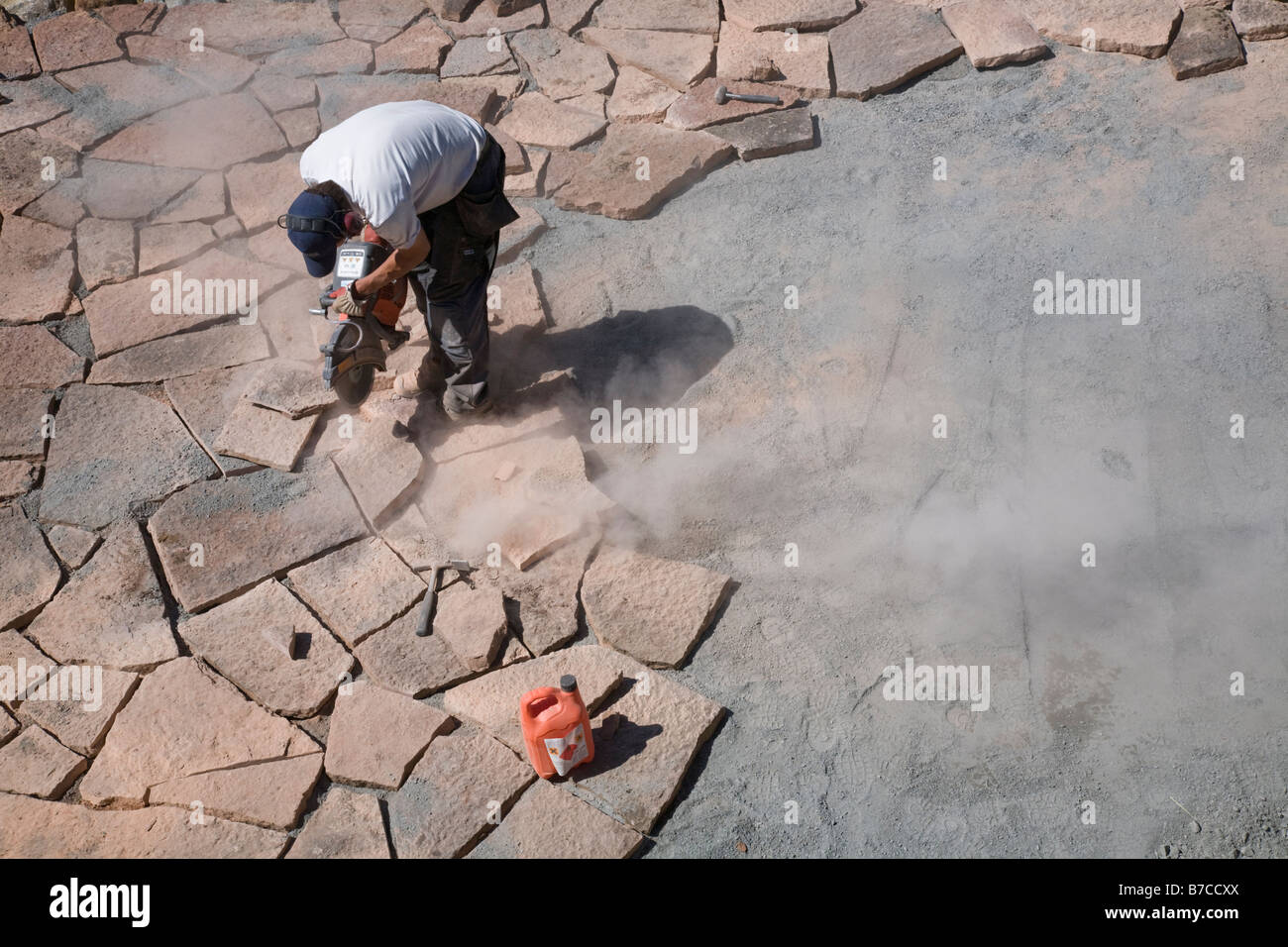 Man cutting and laying limestone slabs on a terrace Stock Photo - Alamy