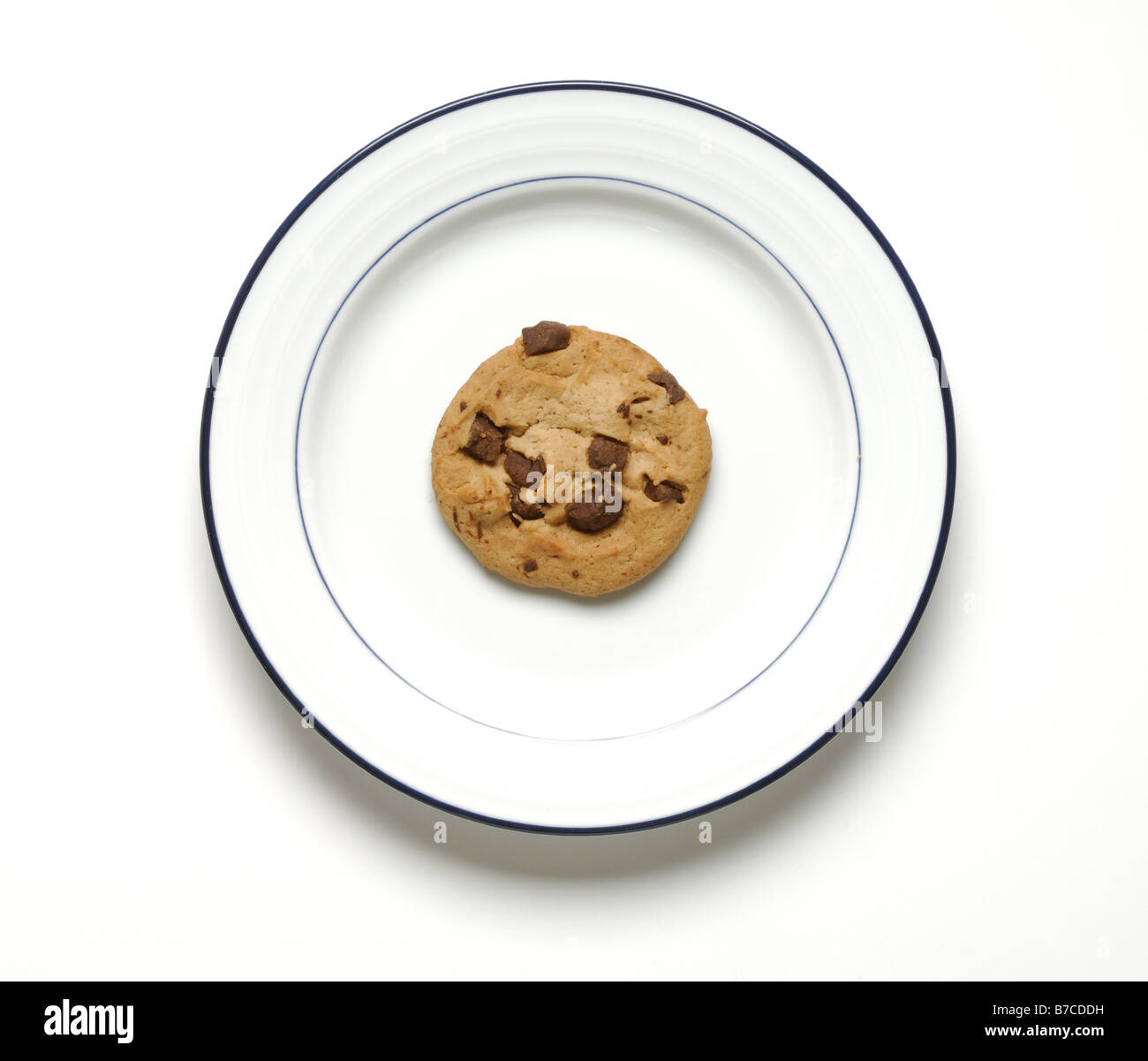 A single chocolate cookie on a round white dinner plate Stock Photo - Alamy