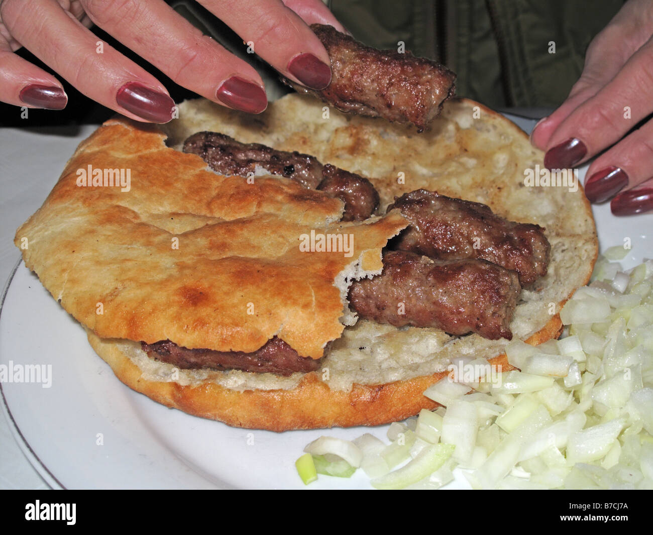 Finger eating Cevapcici or Cevapi Fast Food of Balkans Stock Photo - Alamy