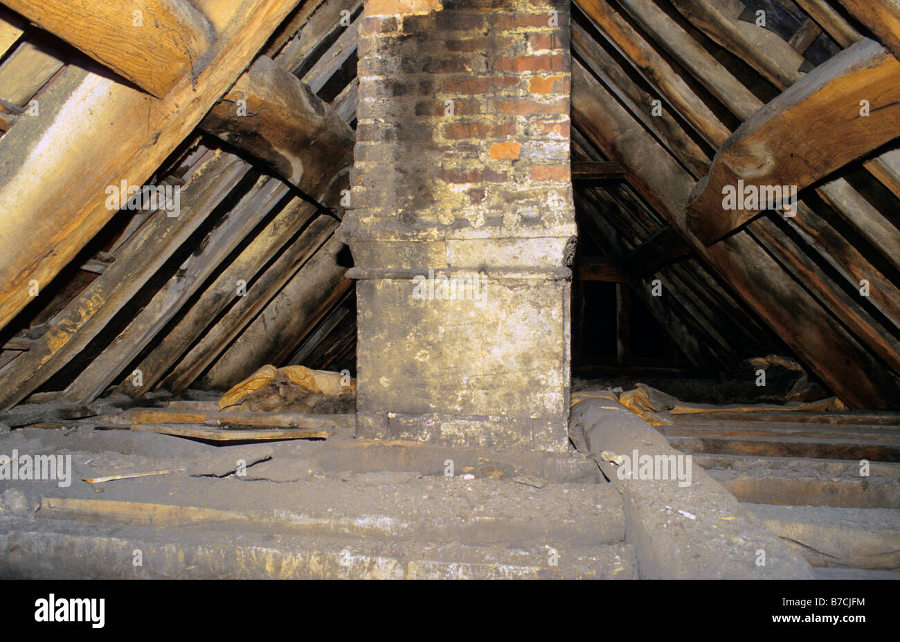 Interior of roof space in old house showing raised chimney stack and ...