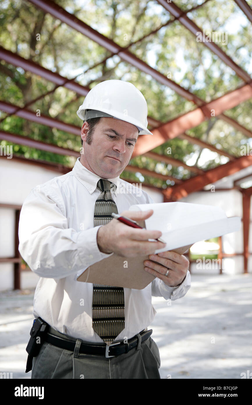 A building inspector on site reviewing his notes Vertical view Stock ...