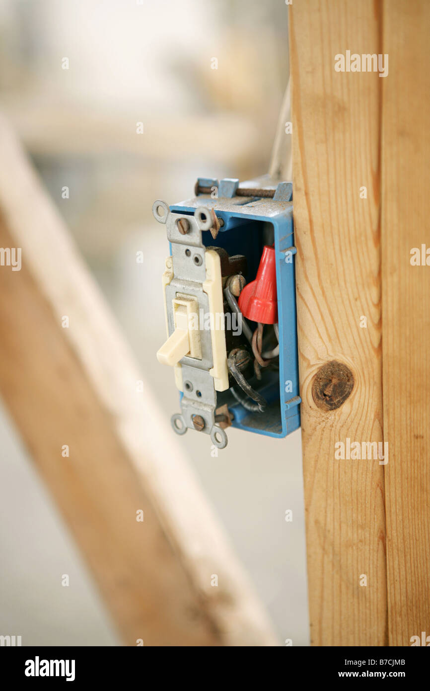 Closeup of an electrical switch box nailed to a wood beam on a ...