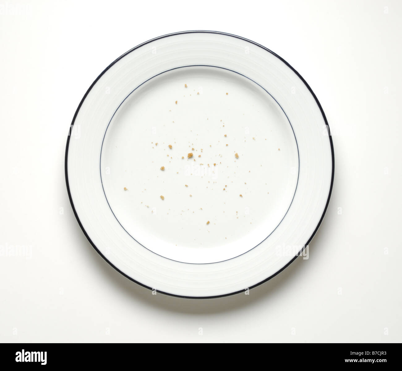 A dinner plate with small crumbs of food Stock Photo - Alamy