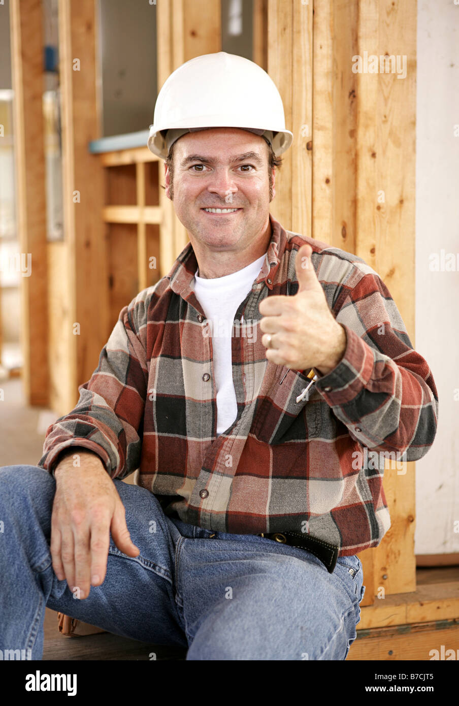 A handsome construction worker giving a thumbsup sign Authentic ...