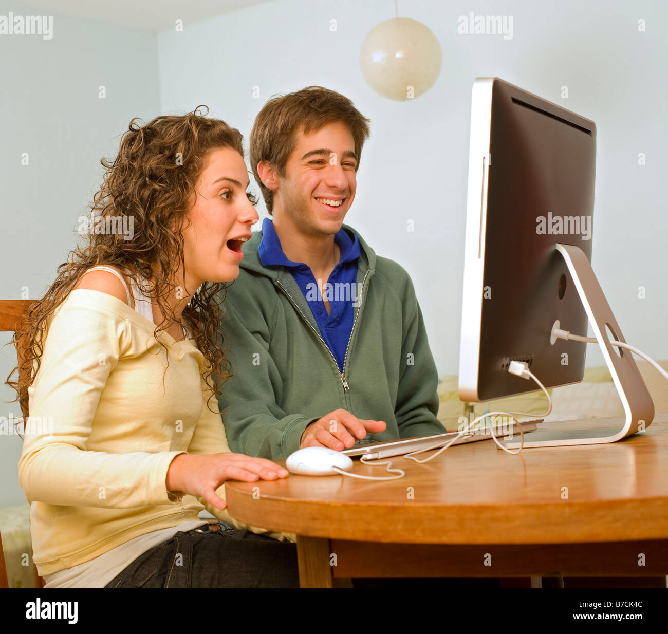 teenager couple having fun with the computer Stock Photo - Alamy