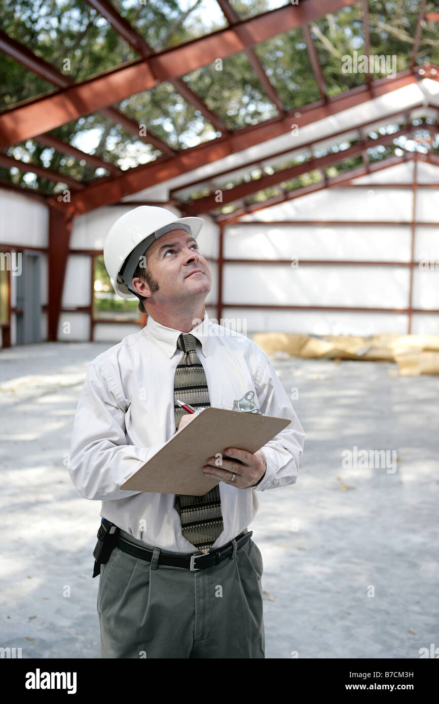 A vertical view of a construction inspector looking at a steel frame ...